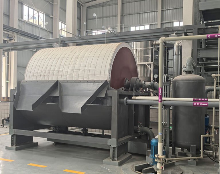 Scraper discharge rotating drum filter